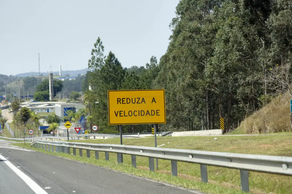 Placa na rodovia alertando para reduzir a velocidade